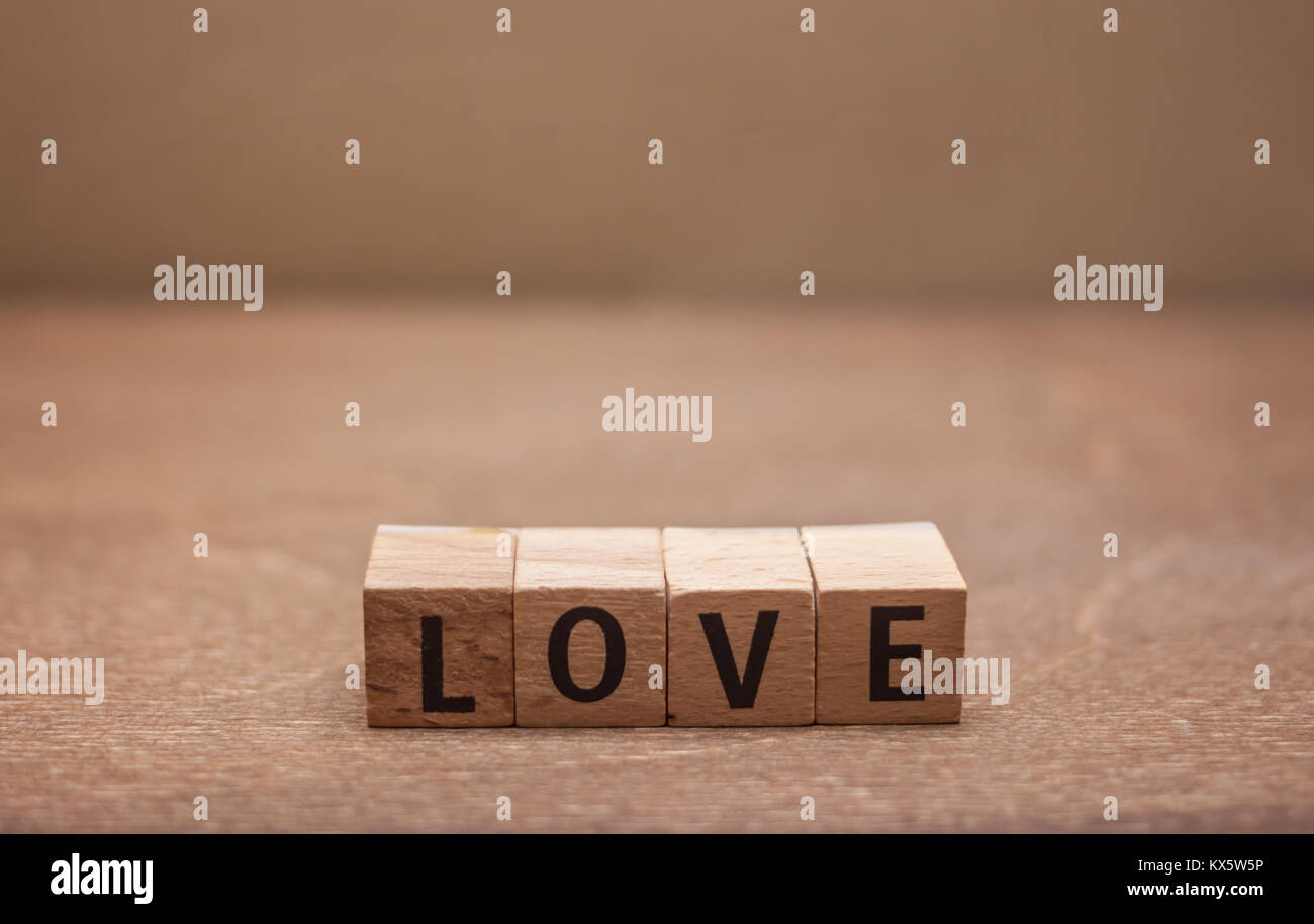 wooden letters forming word love on brown background Stock Photo - Alamy