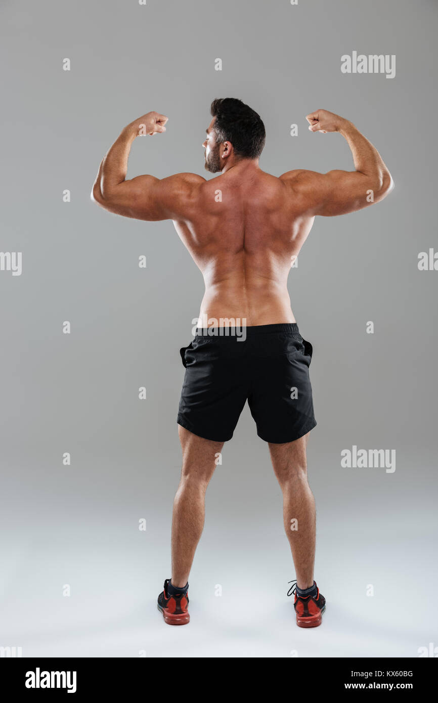 Back view full length portrait of a muscular shirtless male bodybuilder ...