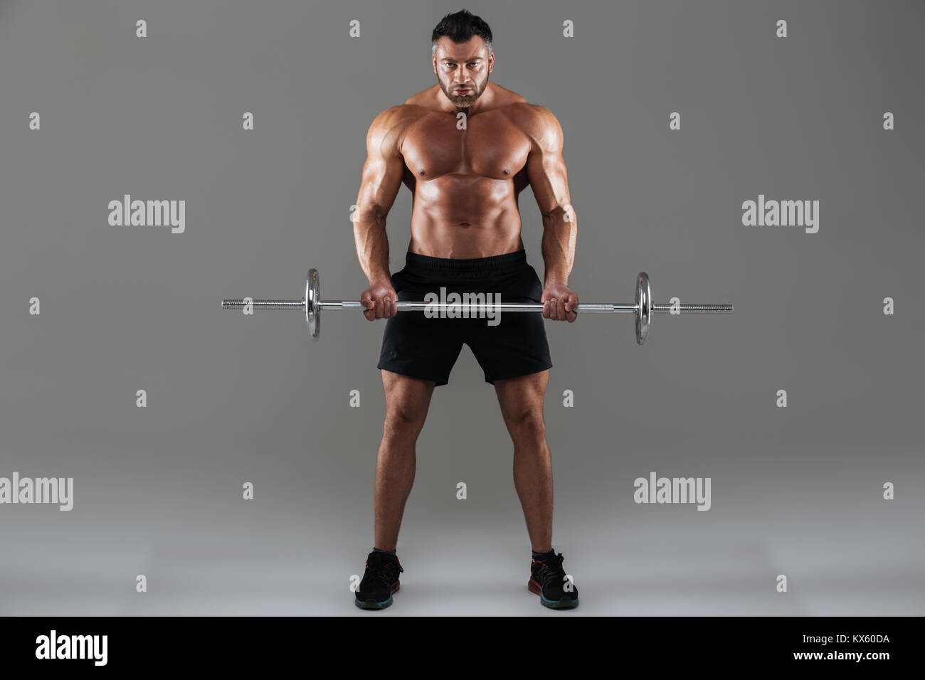 Full length portrait of a concentrated strong shirtless male ...