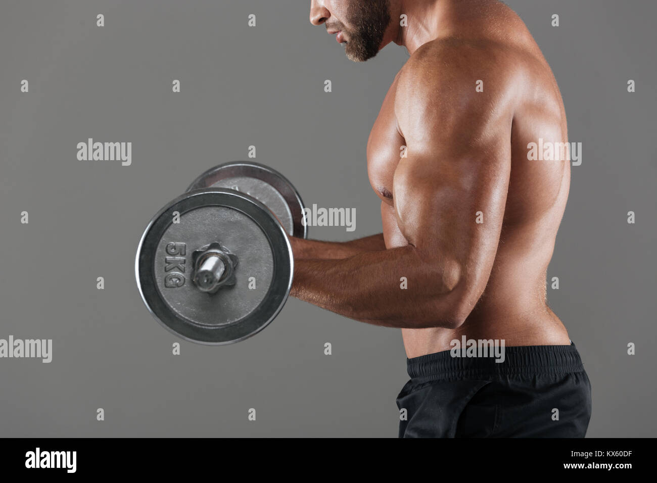 Side view cropped image of a muscular strong shirtless male bodybuilder ...