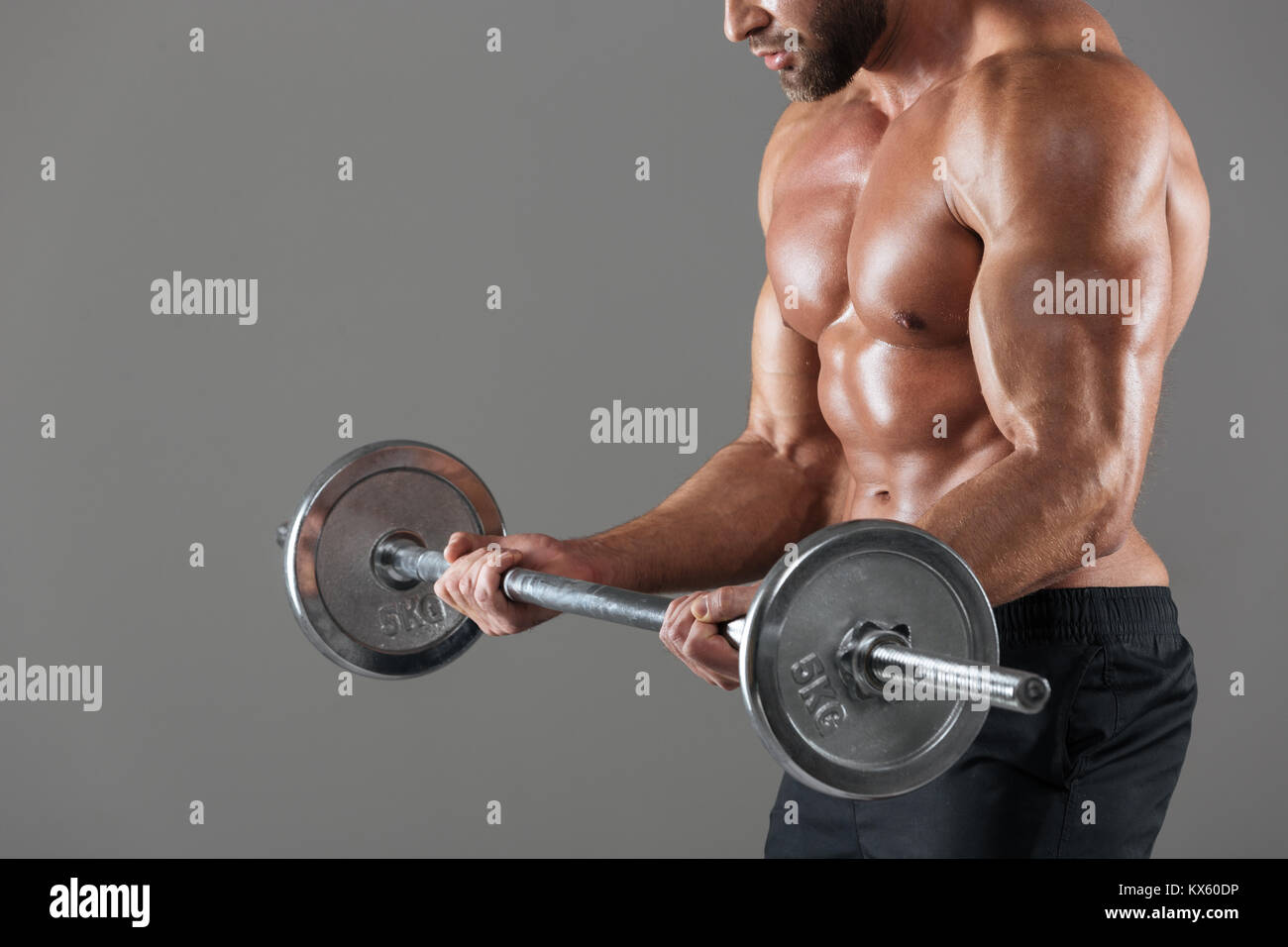 Side view cropped image of a muscular strong shirtless male bodybuilder ...