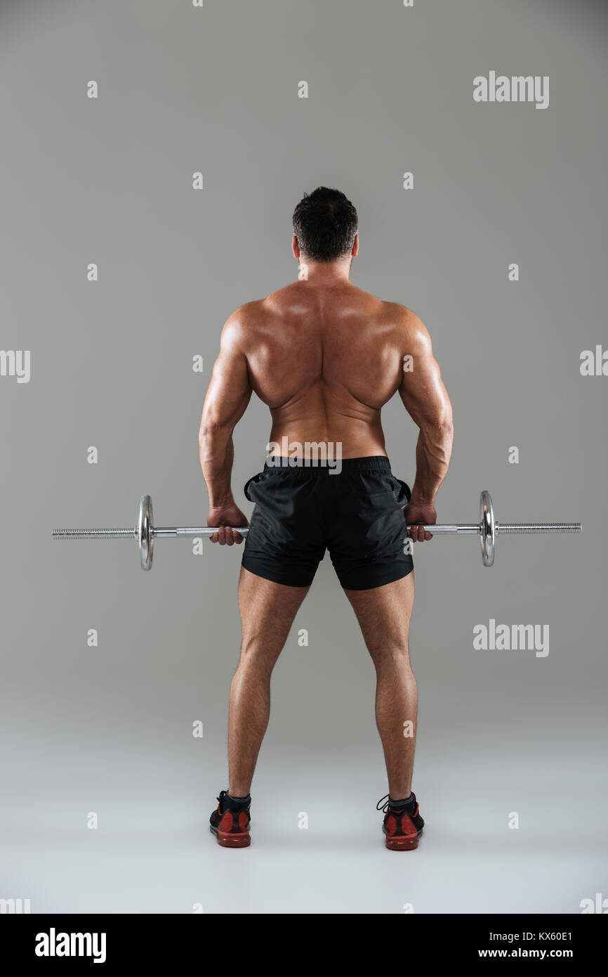 Back view full length portrait of a muscular shirtless male bodybuilder ...