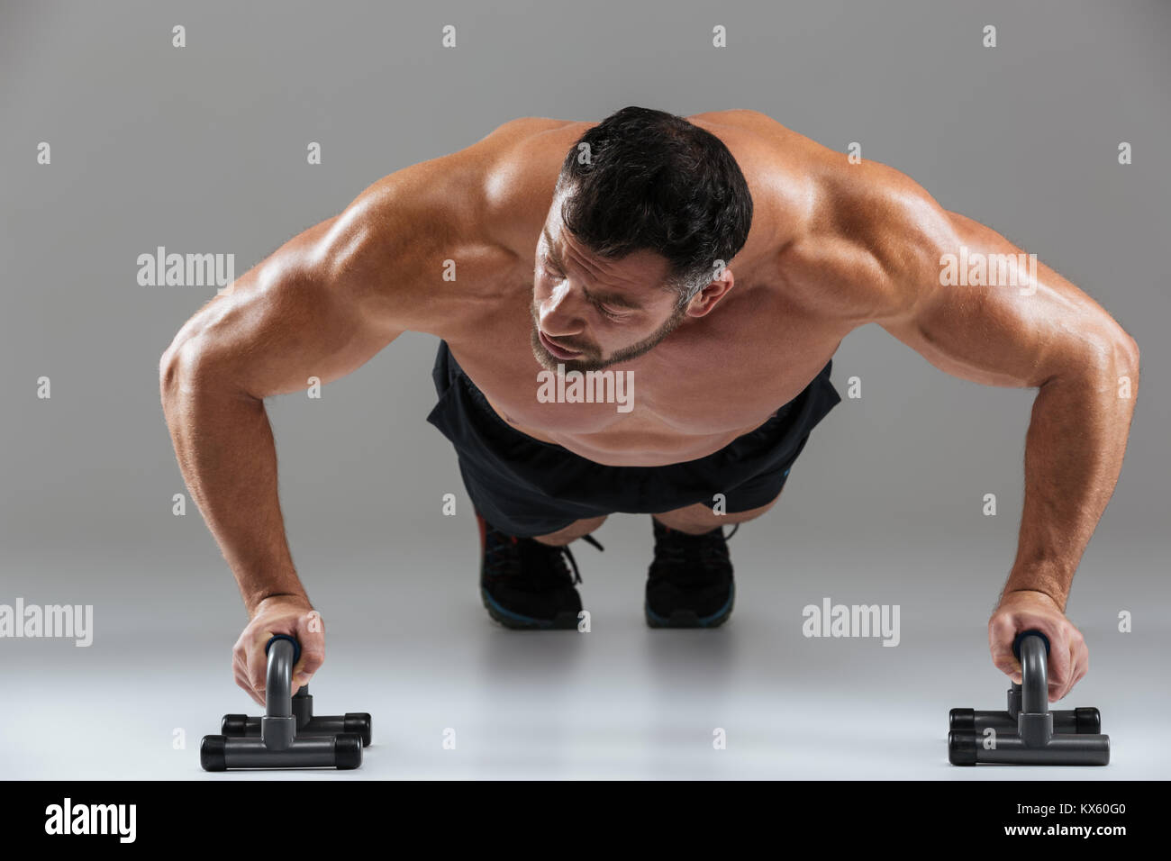 Close up portrait of a muscular strong shirtless male bodybuilder doing ...