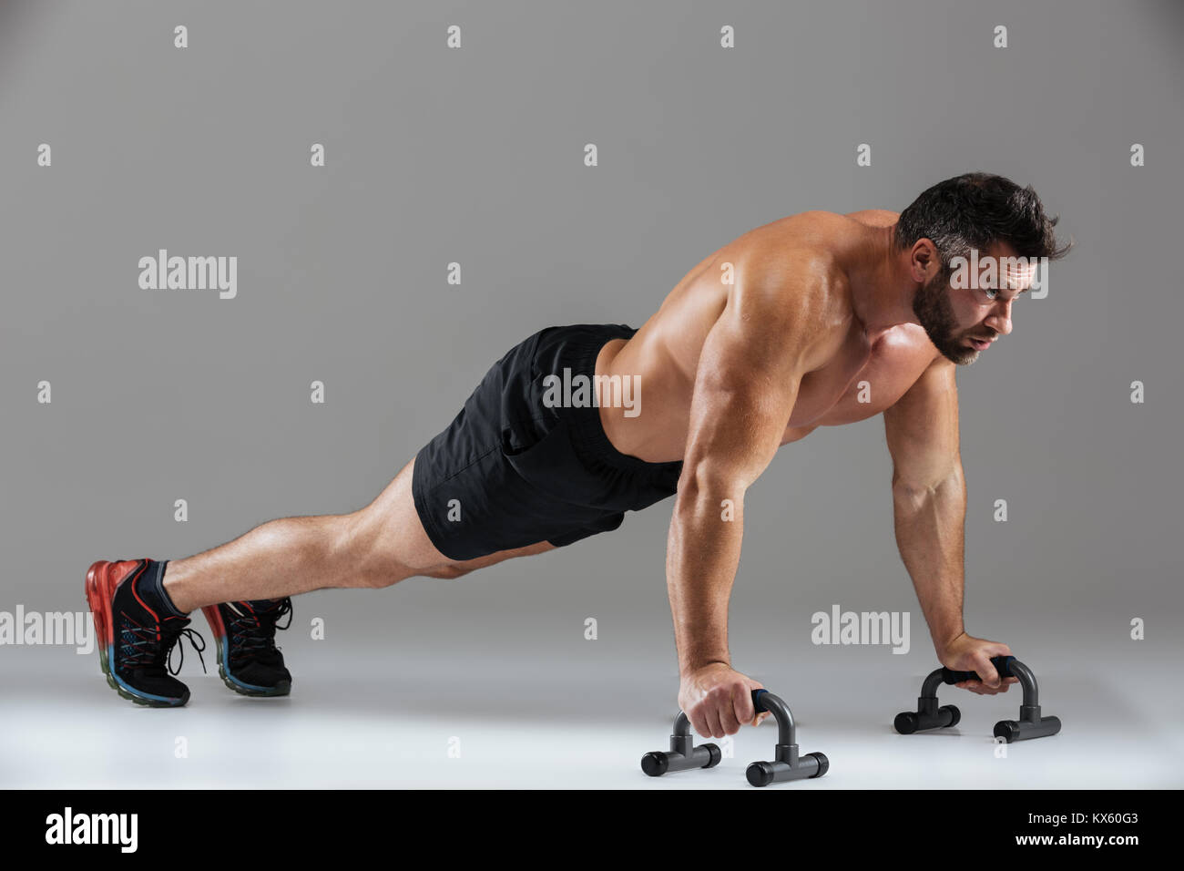 Full length portrait of a fit strong shirtless male bodybuilder doing ...