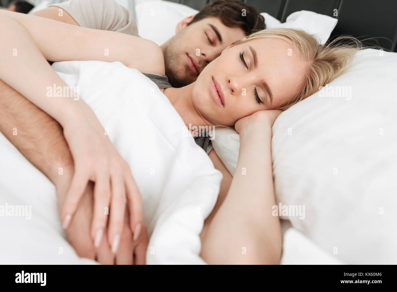 Portrait of calm handsome lovers, young man and woman, sleeping in ...