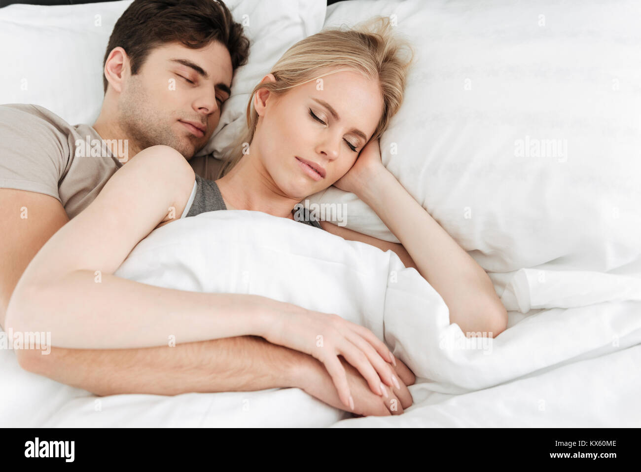 Portrait of calm handsome lovers, young man and woman, sleeping in ...