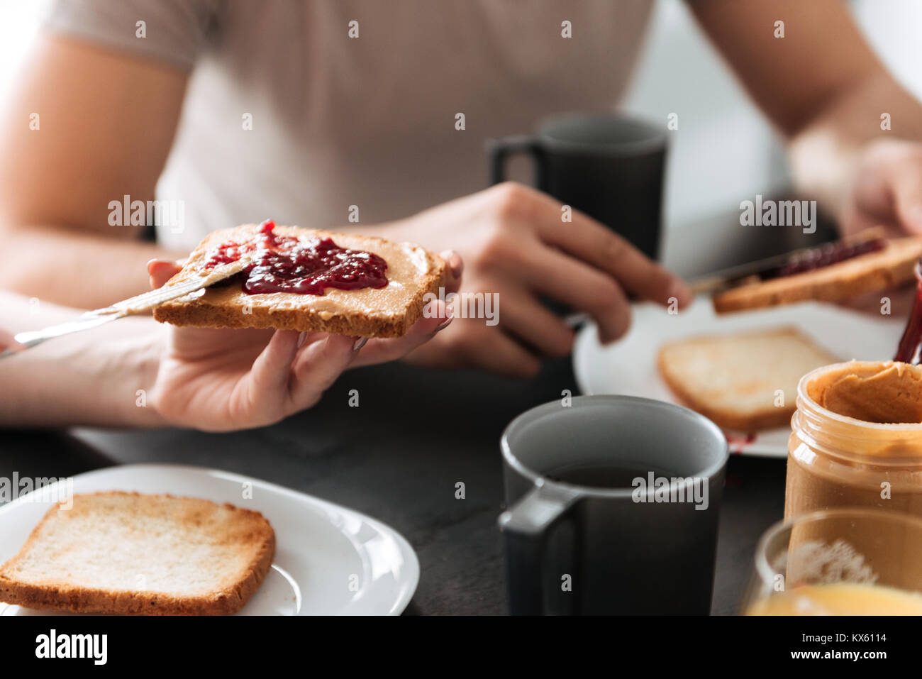 Cropped photo of woman put jam on bread while have breakfast Stock ...