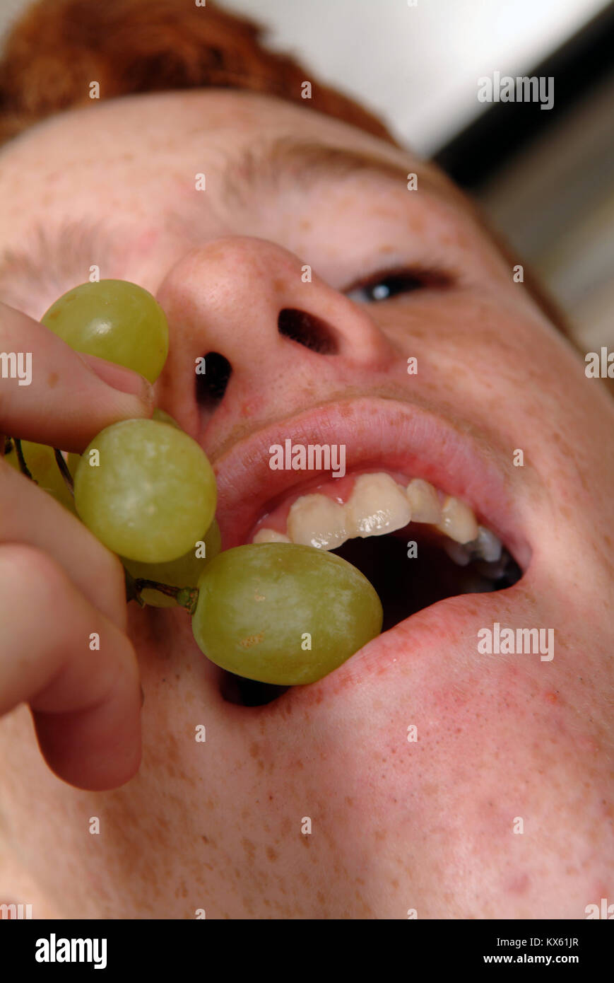 Man eating green grapes Stock Photo - Alamy