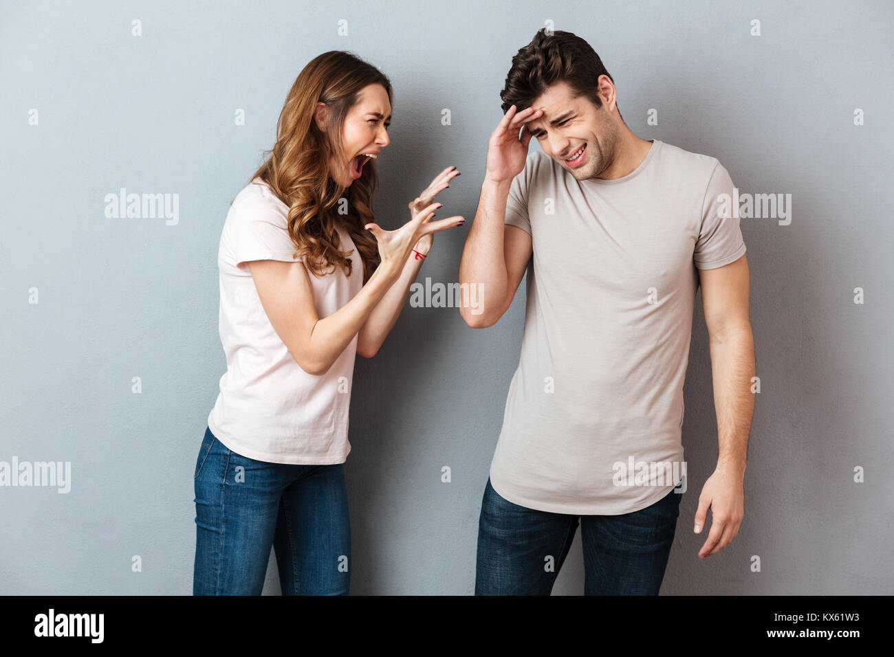 Portrait of an angry young couple having an argument and gesturing over ...
