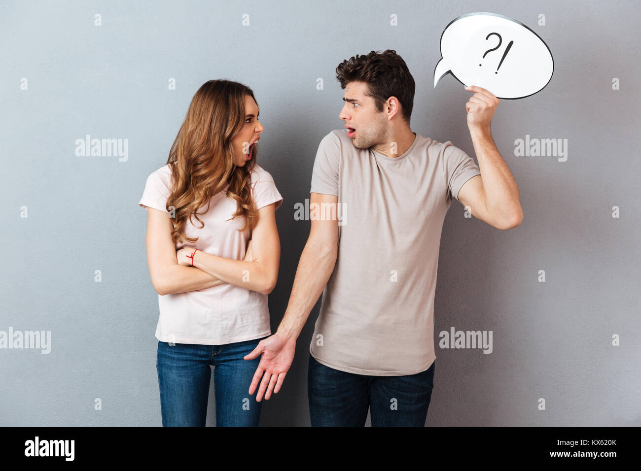 Portrait of a young upset couple having an argument while standing and ...
