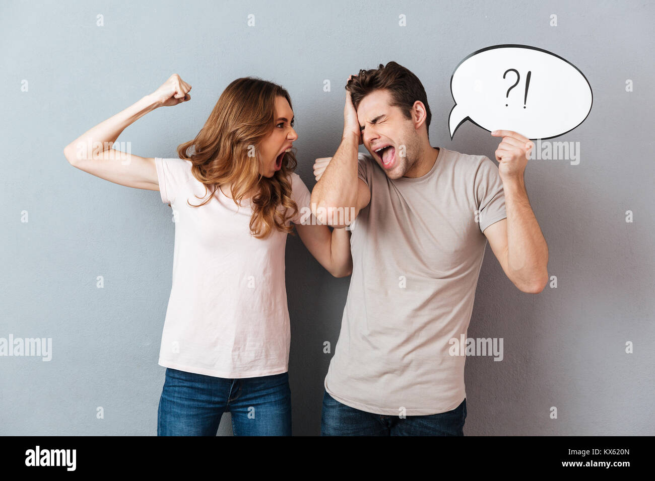 Portrait of a young furious couple having an argument while standing ...