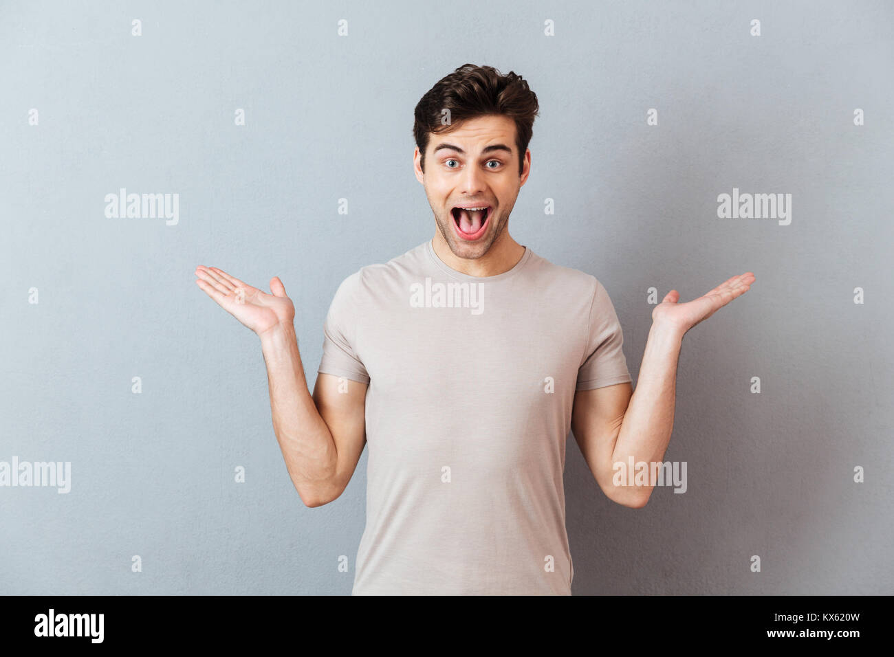 Portrait of an excited happy man gesturing and looking at camera ...
