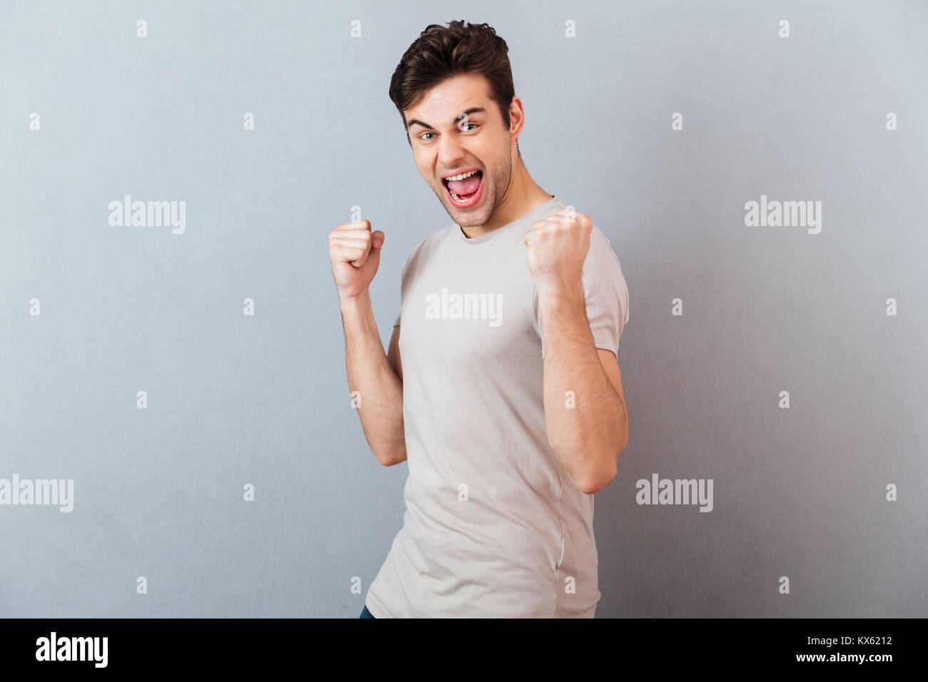 Portrait of a happy satisfied man celebrating success isolated over ...