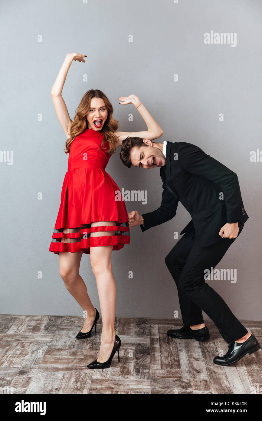Full length portrait of a happy joyful couple dressed in formal wear ...