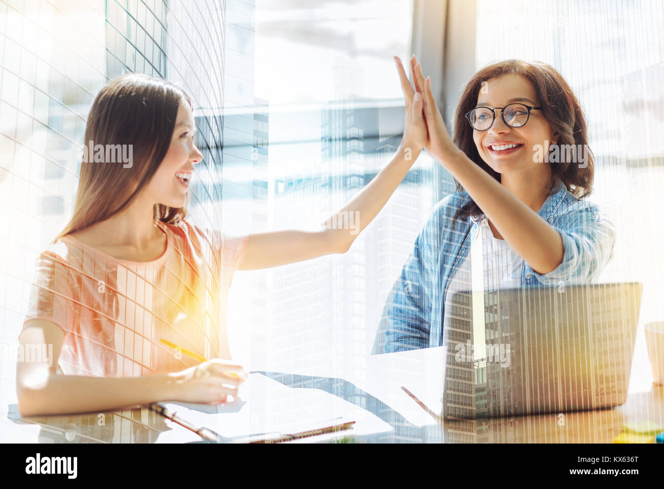 Happy nice colleagues giving each other high five Stock Photo - Alamy