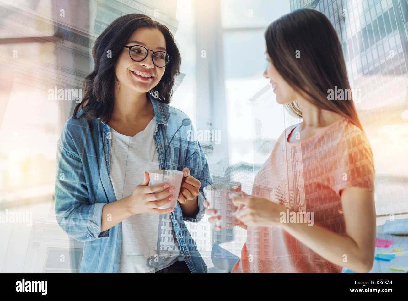 Nice positive women talking to each other Stock Photo - Alamy