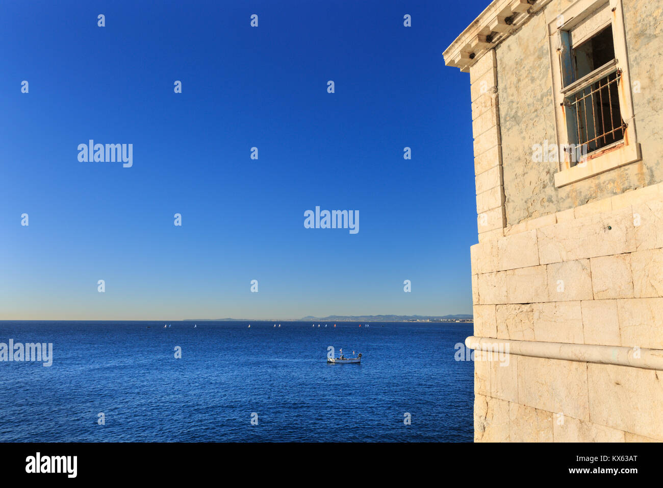 View past an old derelict port building out to the Mediterranean sea ...