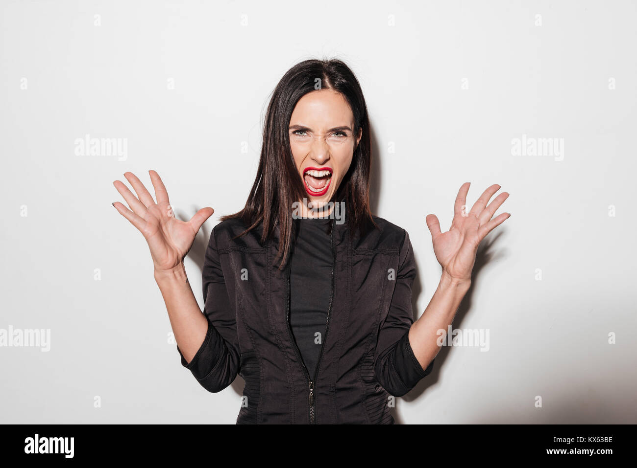 Picture of young angry screaming woman with red lips standing isolated ...