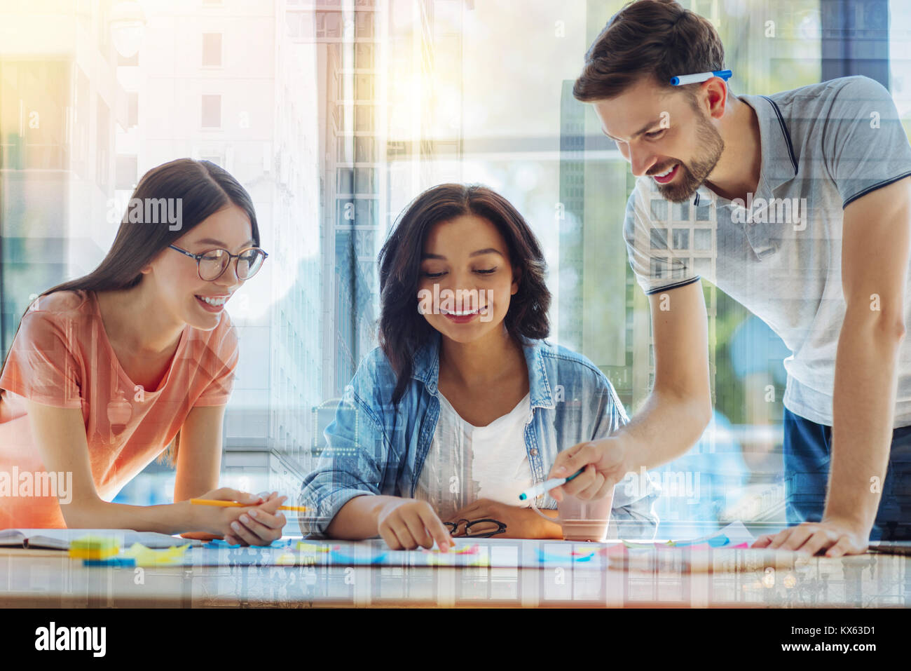 Cheerful young people working on a project Stock Photo - Alamy