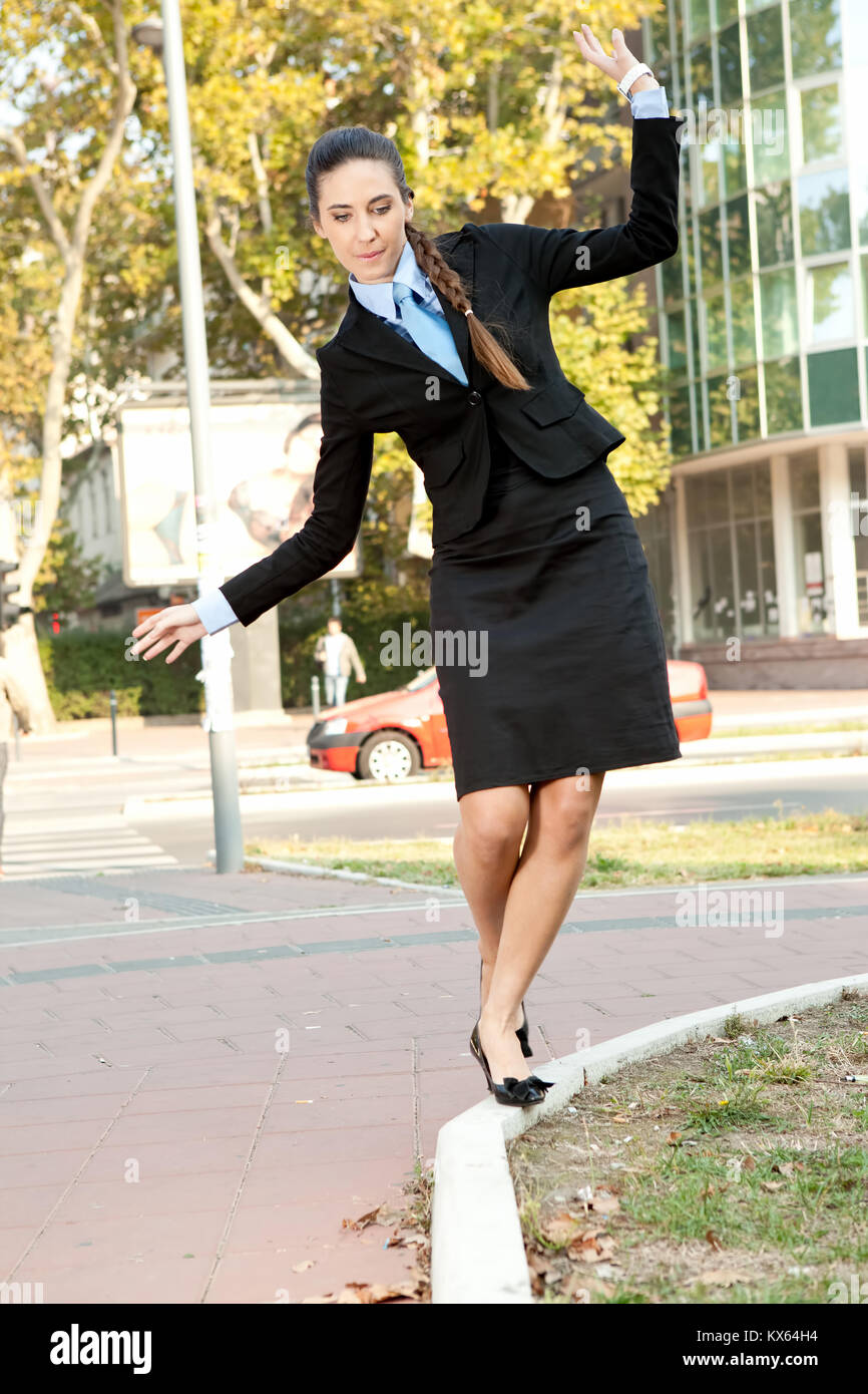funny businesswoman trying to keep balance on the curb Stock Photo - Alamy