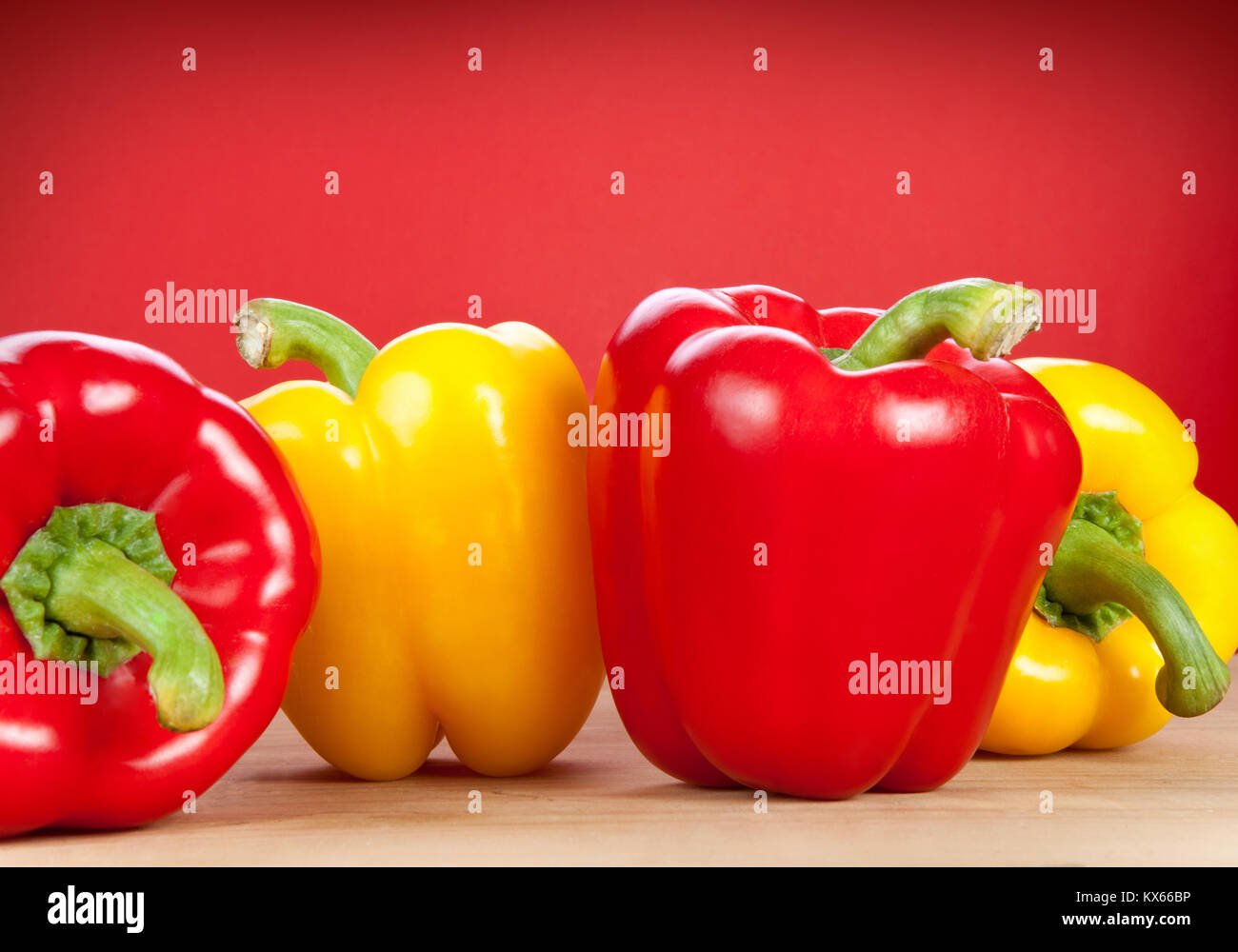red and yellow peppers on red background Stock Photo - Alamy