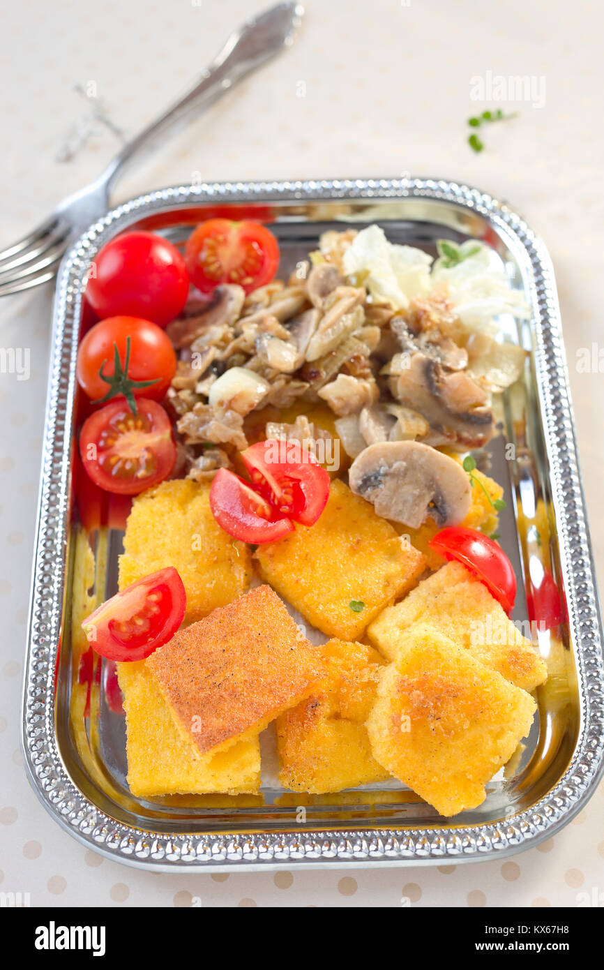 Fried polenta with champions and tomato Stock Photo - Alamy