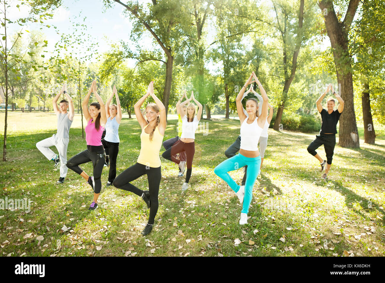 tree position, large group of young people doing yoga, outdoor Stock ...