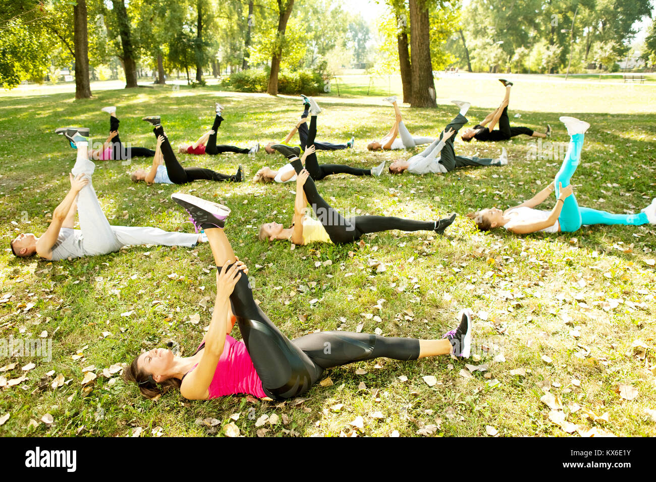 group stretching workout, large group stretches outdoor on a green ...