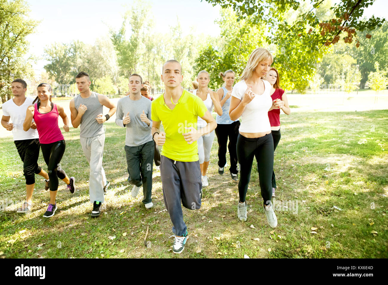 large group of young people running in park Stock Photo - Alamy