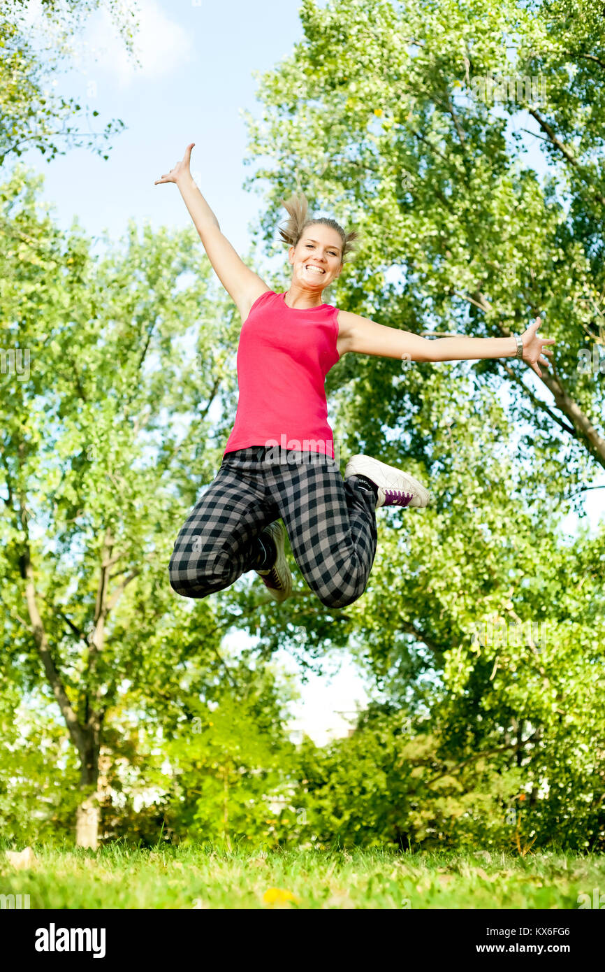 young happy woman jumping in park Stock Photo - Alamy