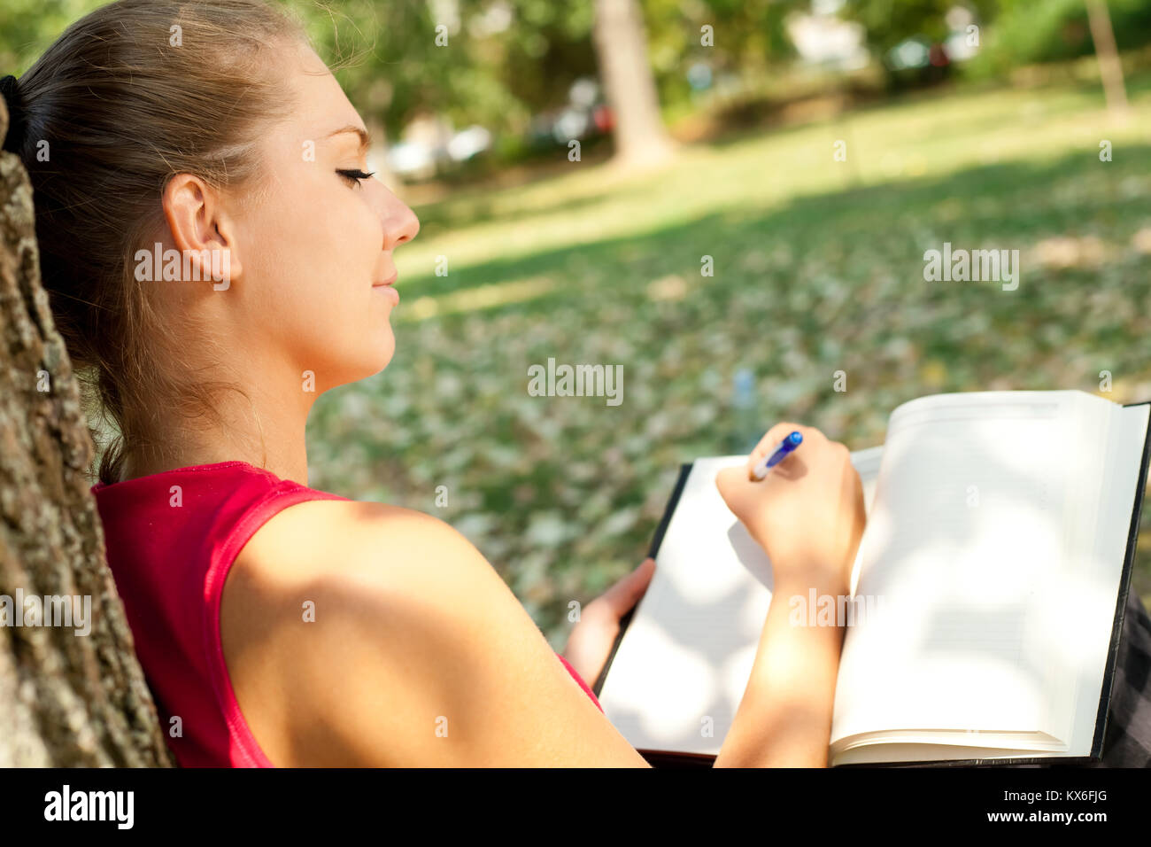 young girl writer in park, writing book Stock Photo - Alamy