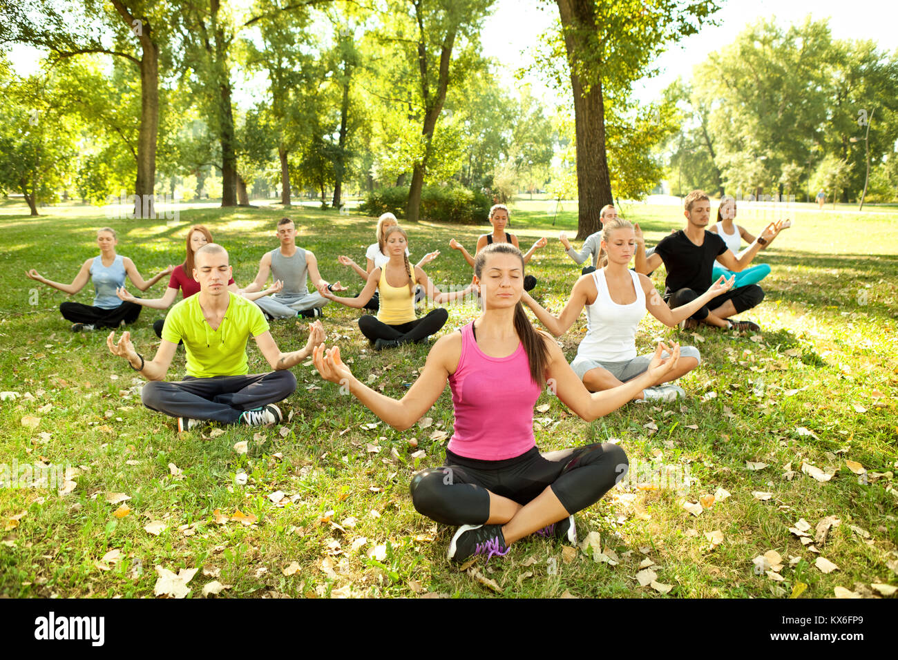 a group of people doing yoga in a city park Stock Photo - Alamy
