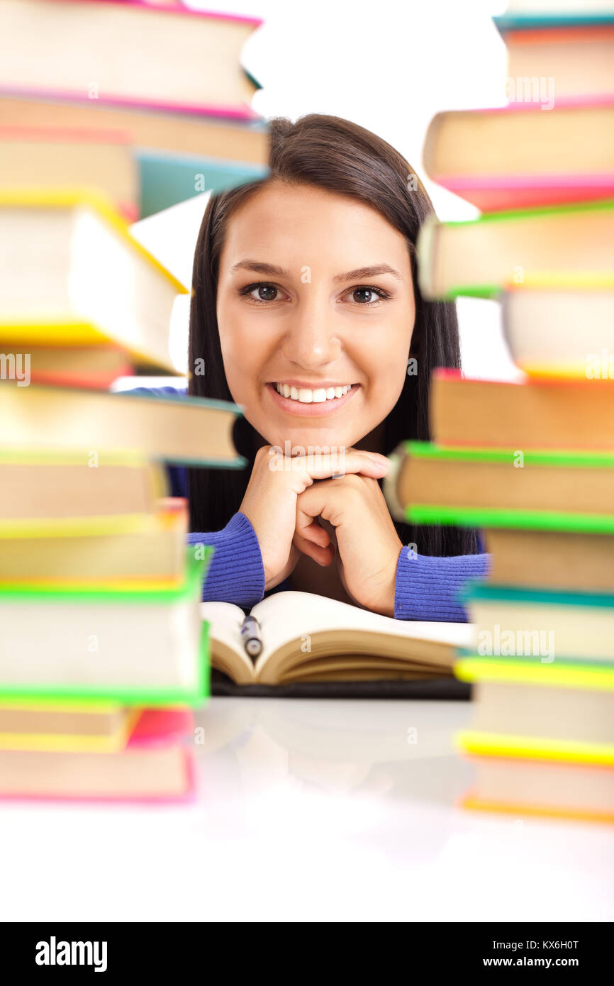 smiling student girl between stack of books, isolated on white ...
