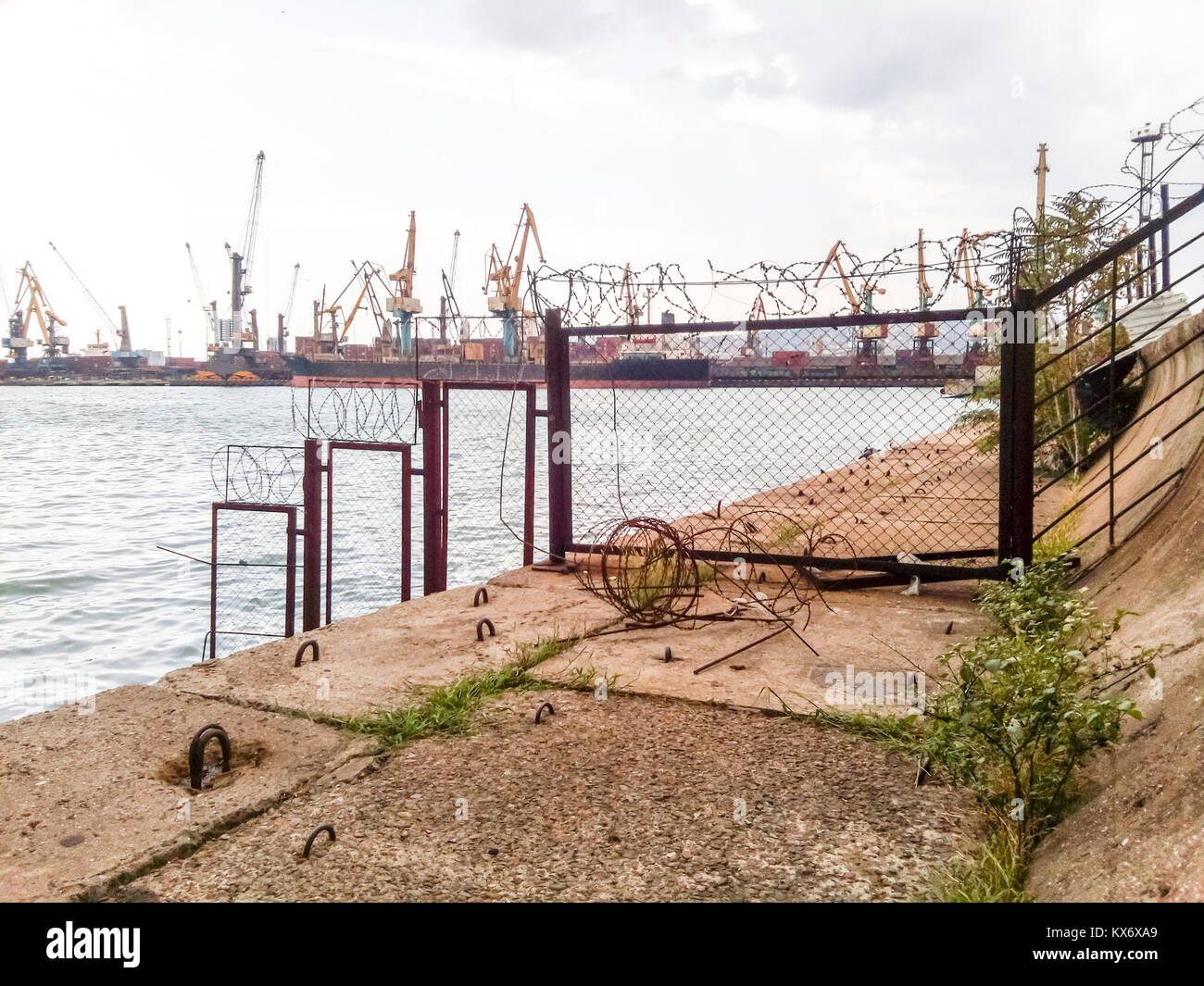 View of the sea and city beach from the port quay. Industrial port with ...
