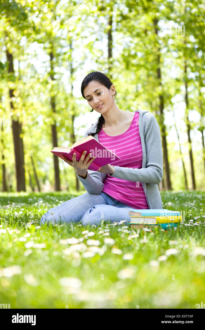 young beautiful girl reading a book outdoor Stock Photo - Alamy