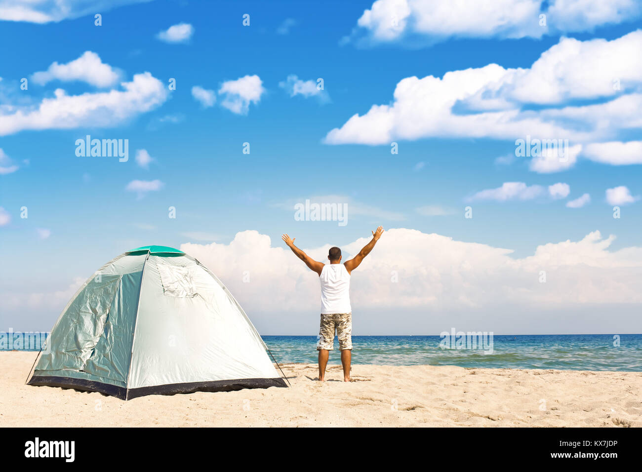 handsome man with tent enjoying camping recreation at a wonderful ...