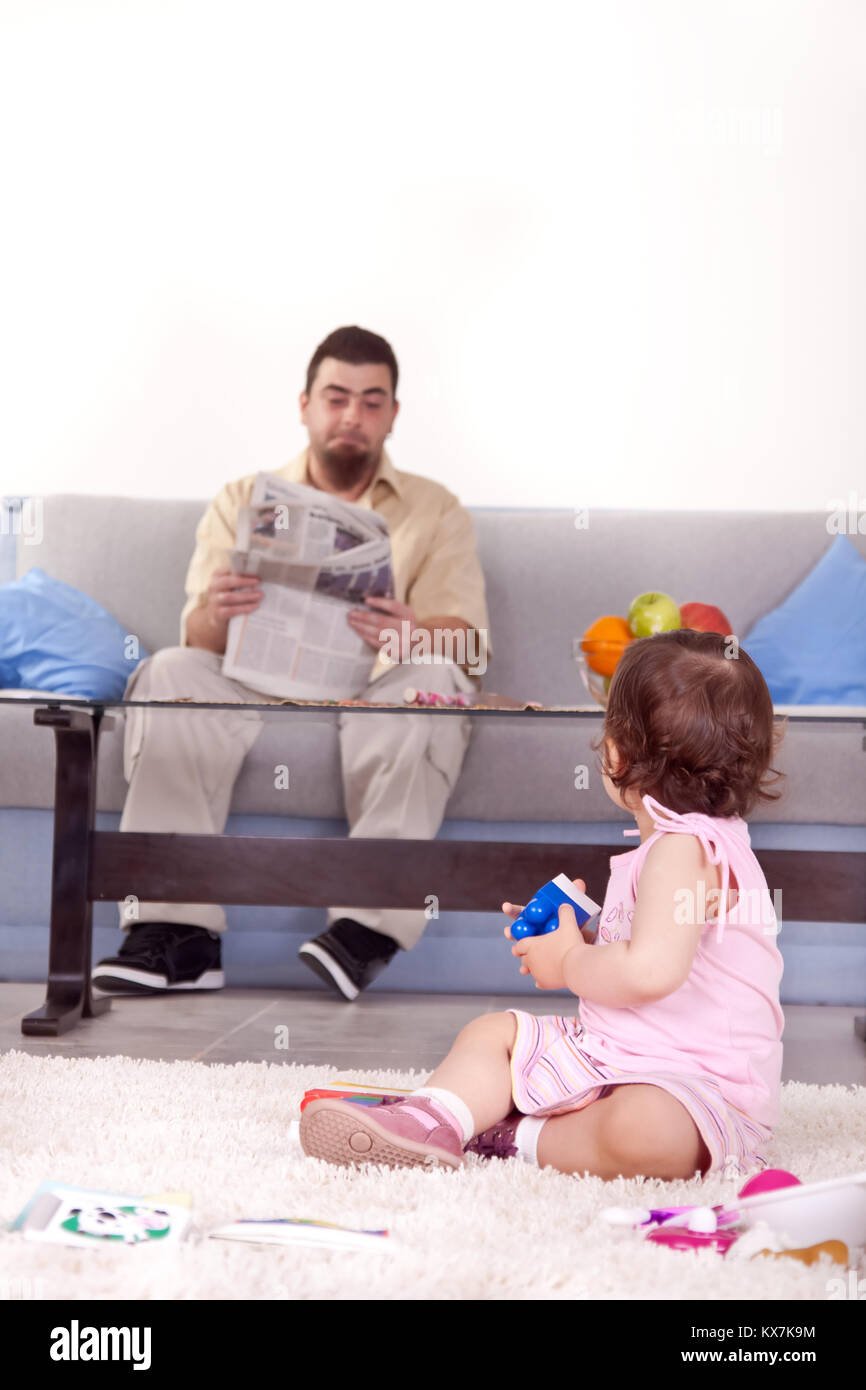 little baby playing on floor his father reading newspaper Stock Photo ...
