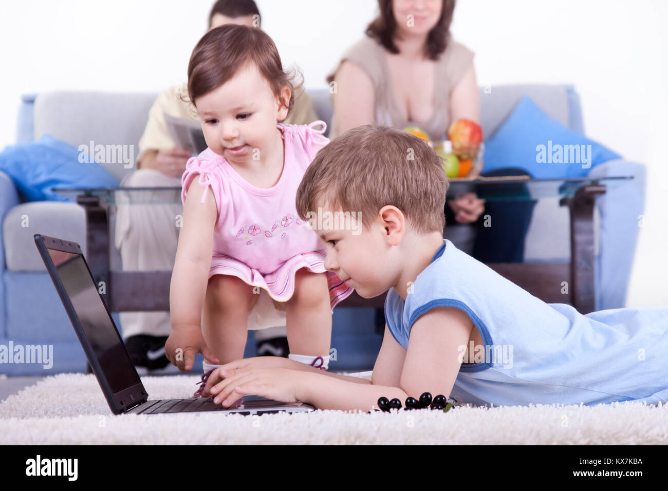 boy playing computer with younger sister at home Stock Photo - Alamy