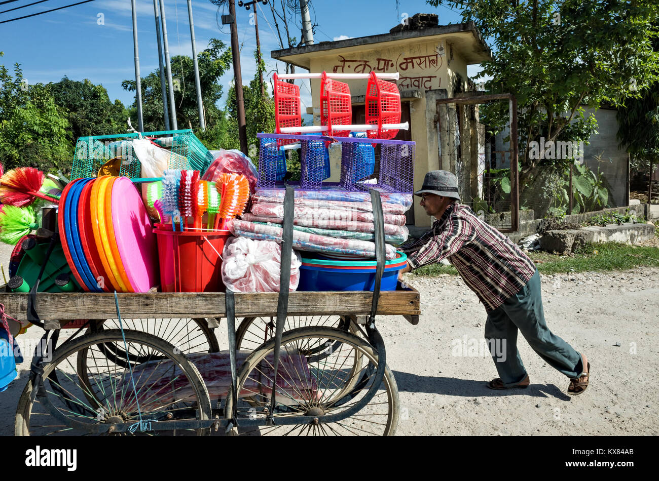 a street vendor selling plastic utilities on a push cart in Hetauda ...