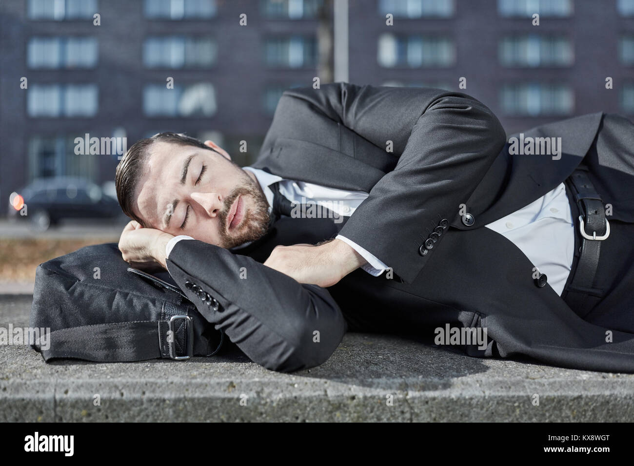 Exhausted businessman is taking an nap outdoor in a break Stock Photo ...