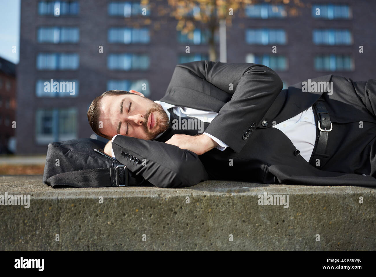 Exhausted businessman is sleeping outdoor and resting Stock Photo - Alamy