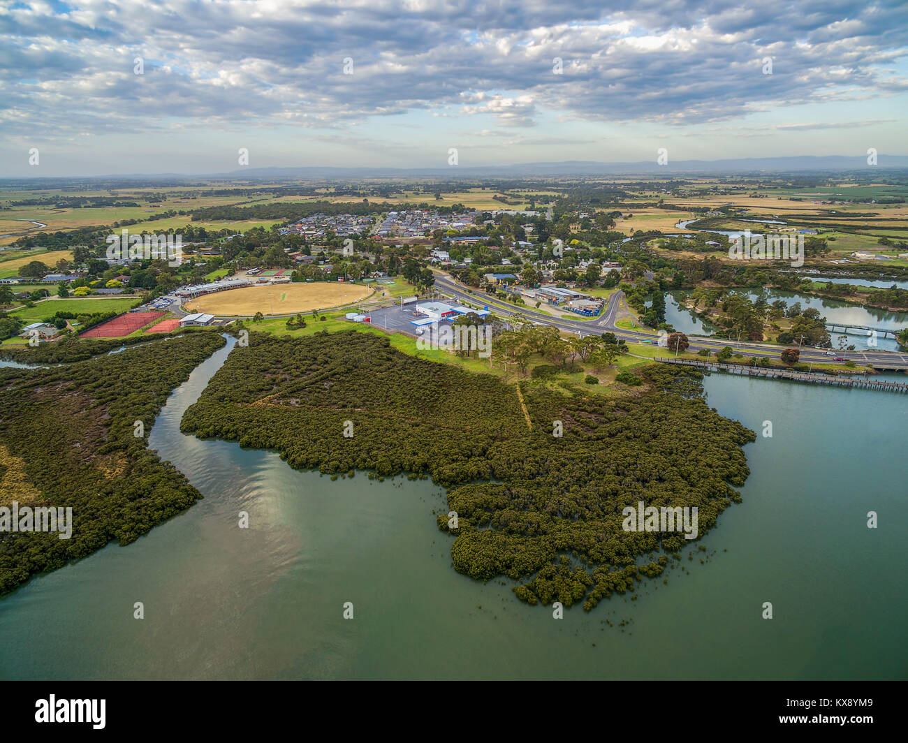 Aerial view of mangroves and small coastal town in Australia at sunset ...