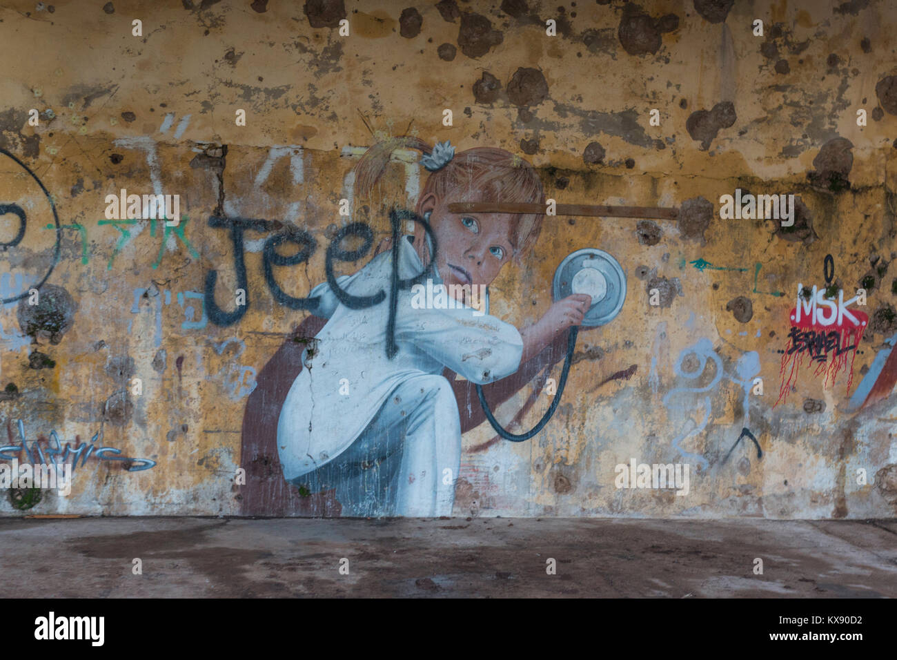 A graffiti of a child doctor on a bullet perforated wall in the Golan ...