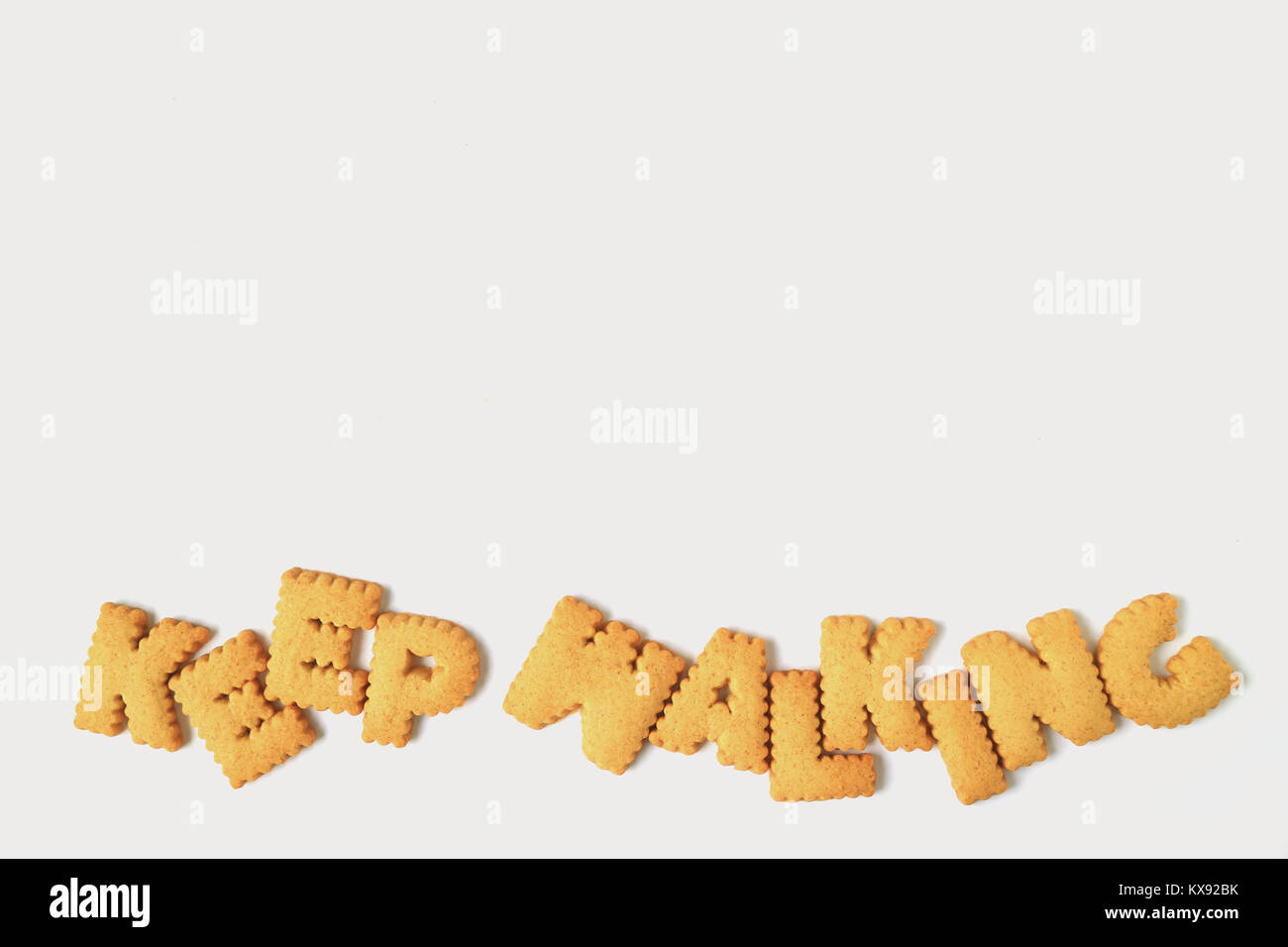 The word KEEP WALKING made with alphabet shaped biscuits isolated on ...