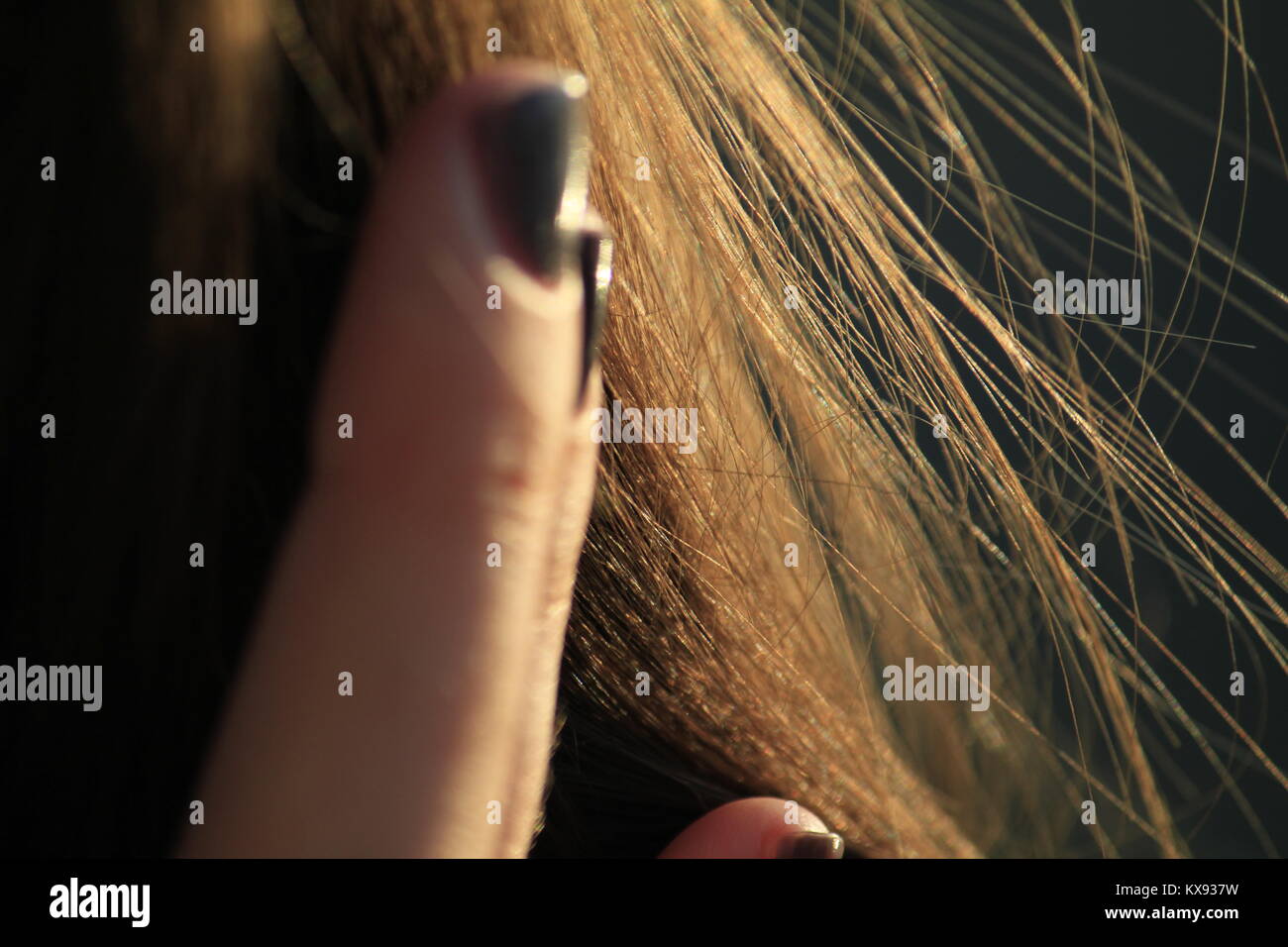 Girl running through her hair with her fingers on a sunny afternoon ...