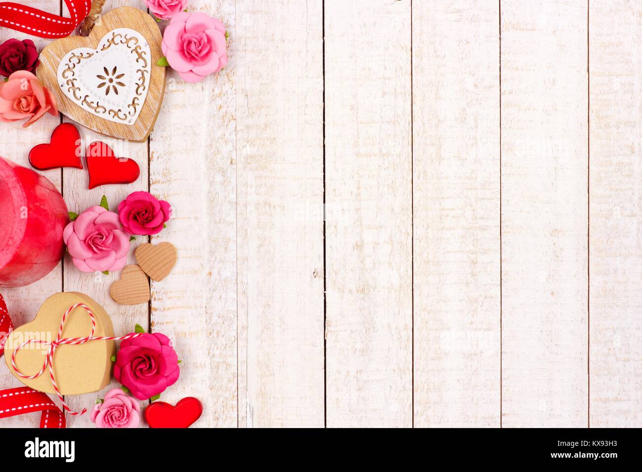 Valentines Day side border of hearts, flowers, gifts and decor against ...