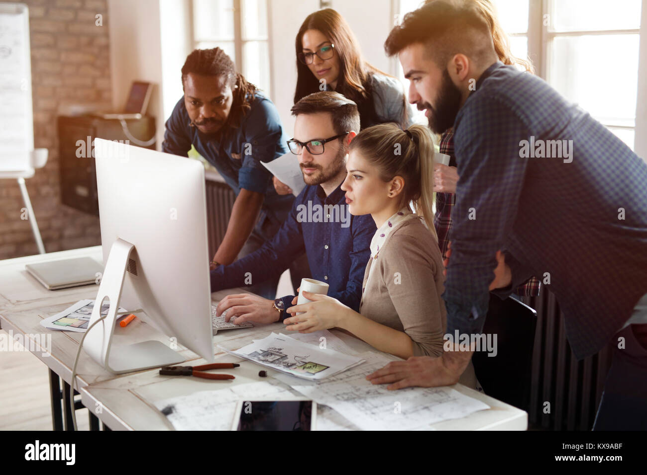 Group of young designers working as team Stock Photo - Alamy