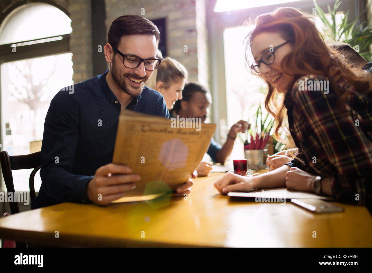 Happy colleagues from work socializing in restaurant Stock Photo - Alamy