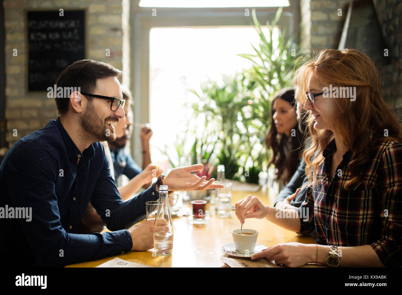 Happy colleagues from work socializing in restaurant Stock Photo - Alamy