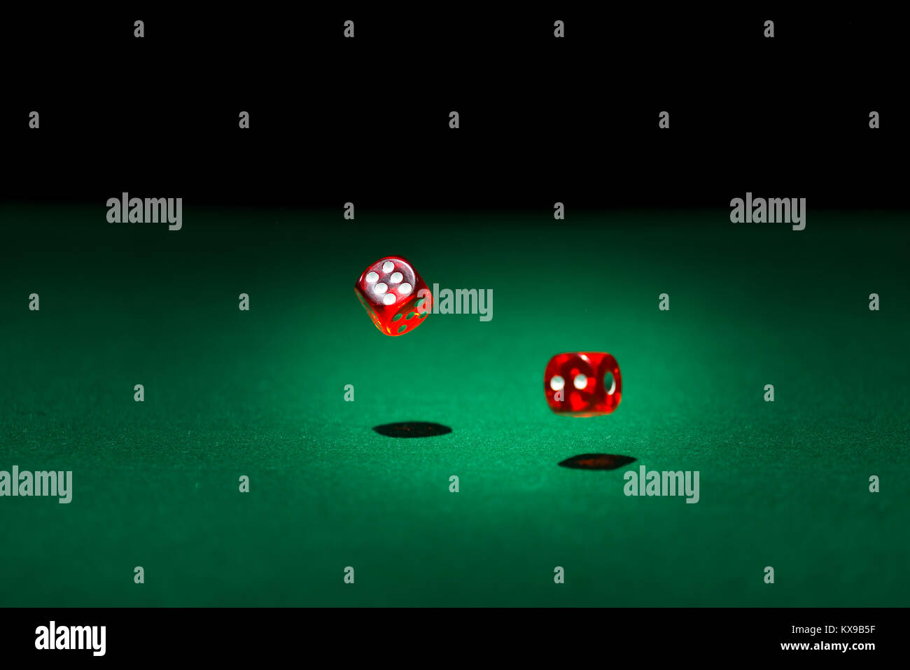two rolling dice falling on green table Stock Photo - Alamy